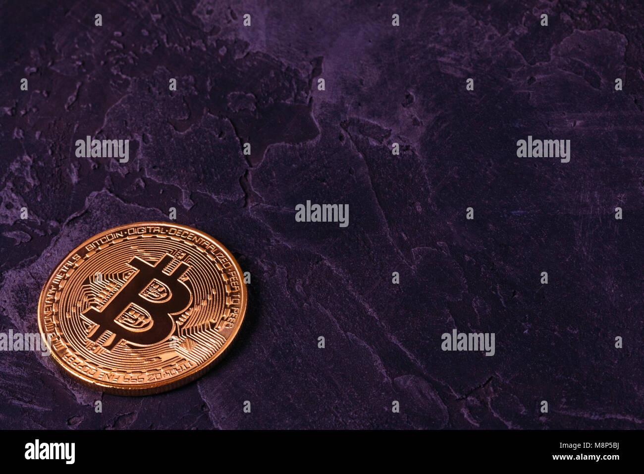 Gold coin bitcoin crypto currency on a dark purple background of ...