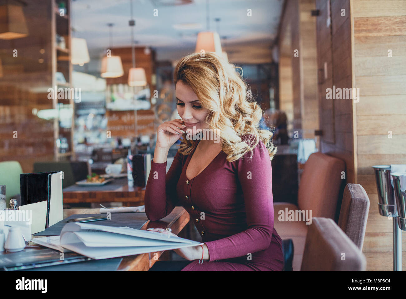 Woman sitting in restaurant hi-res stock photography and images - Alamy