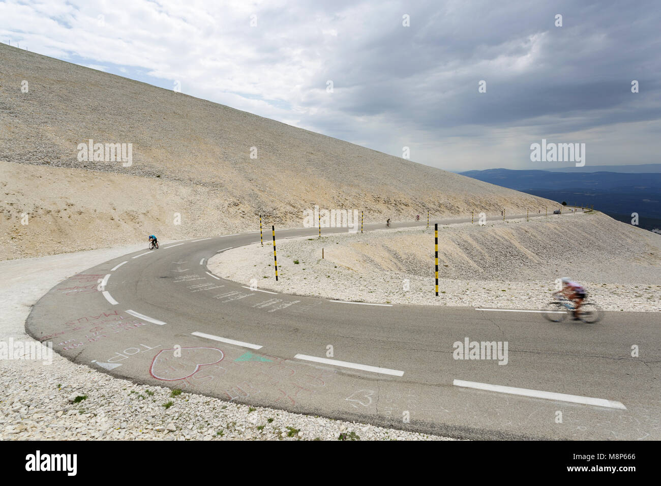 Cyclists climbing and descending from the top of Mount Ventoux ...