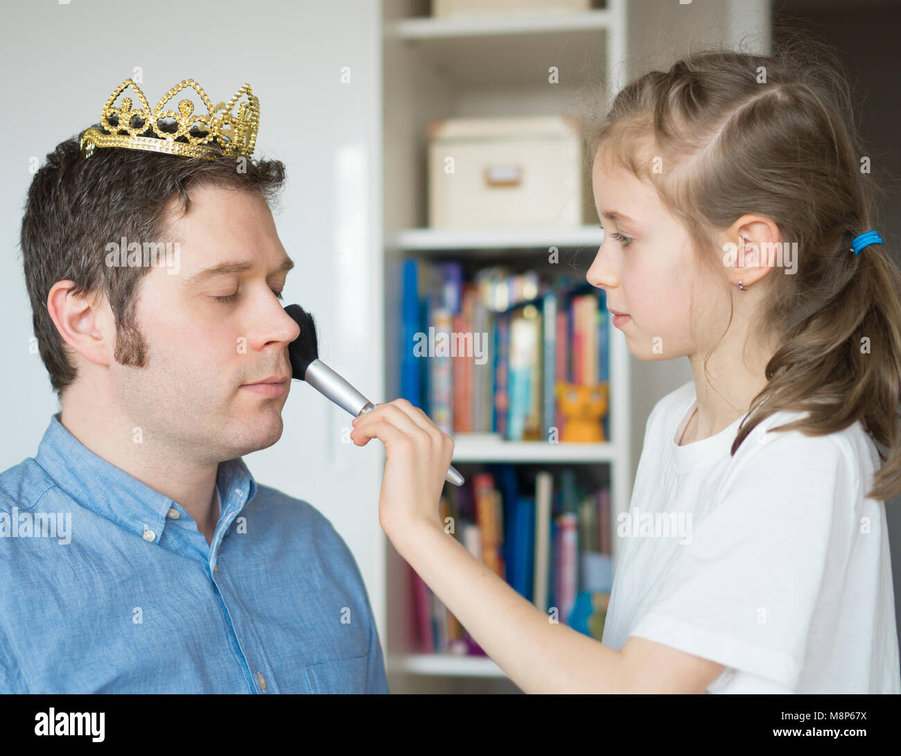 Cute little girl making makeup to her dad Stock Photo - Alamy