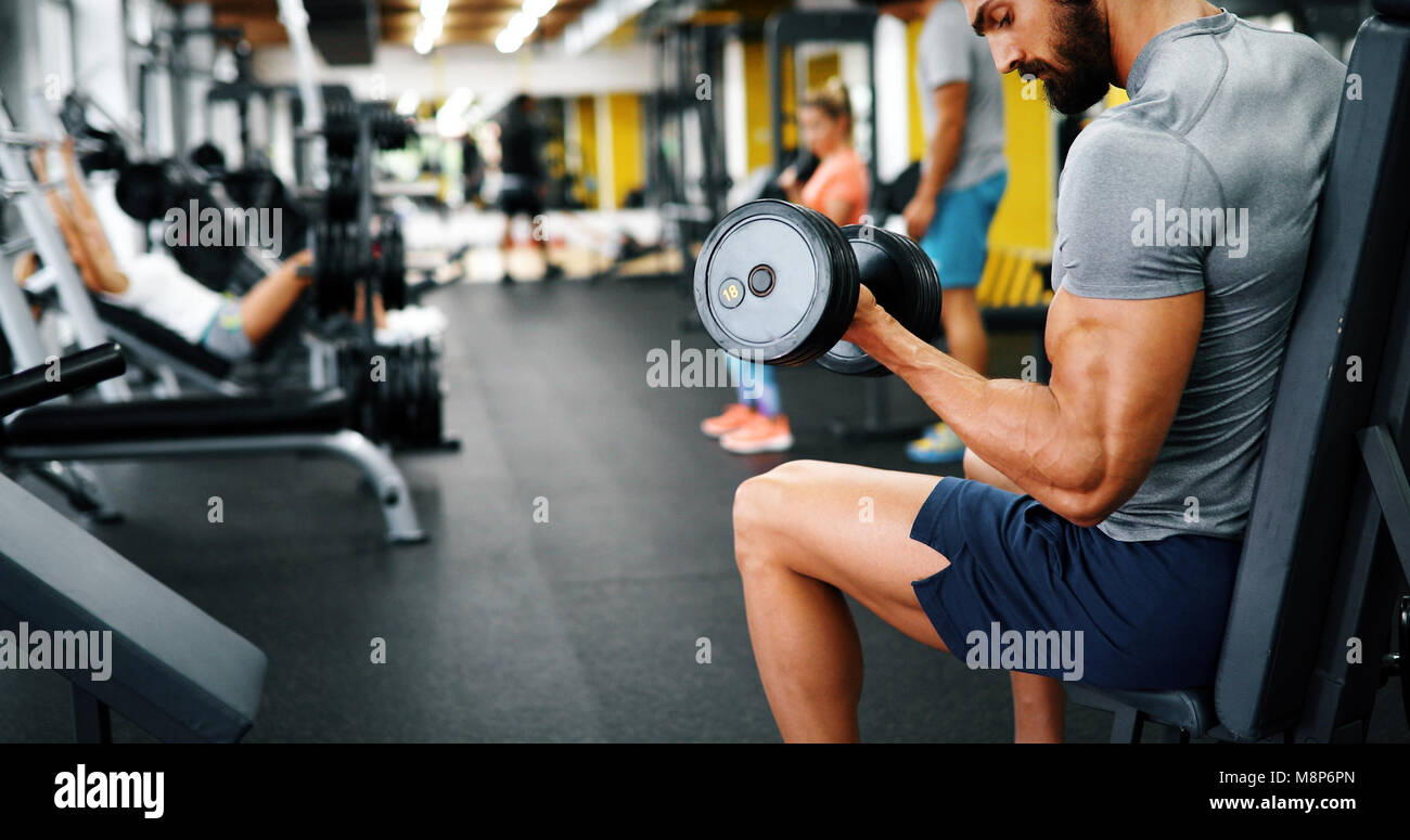 Young handsome man doing exercises in gym Stock Photo - Alamy