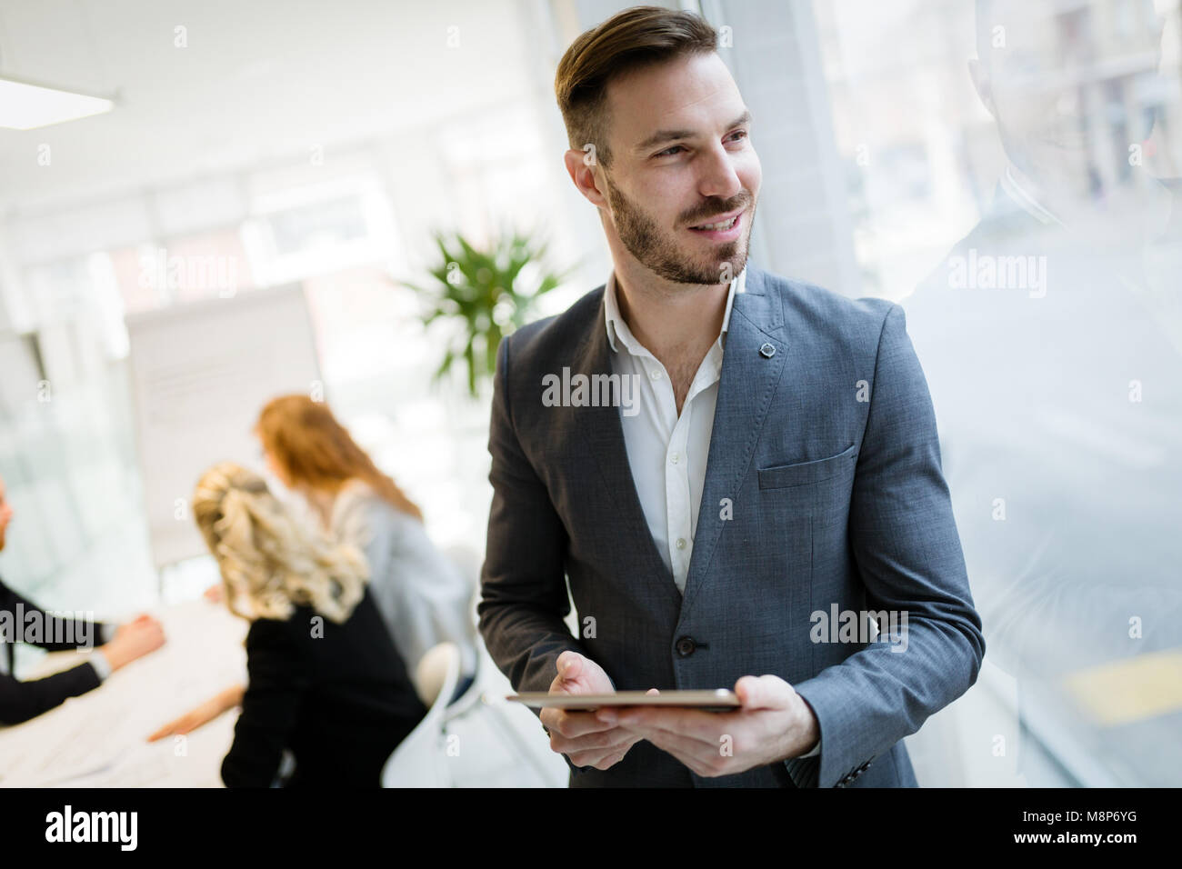 Businessman in modern office using tablet Stock Photo - Alamy
