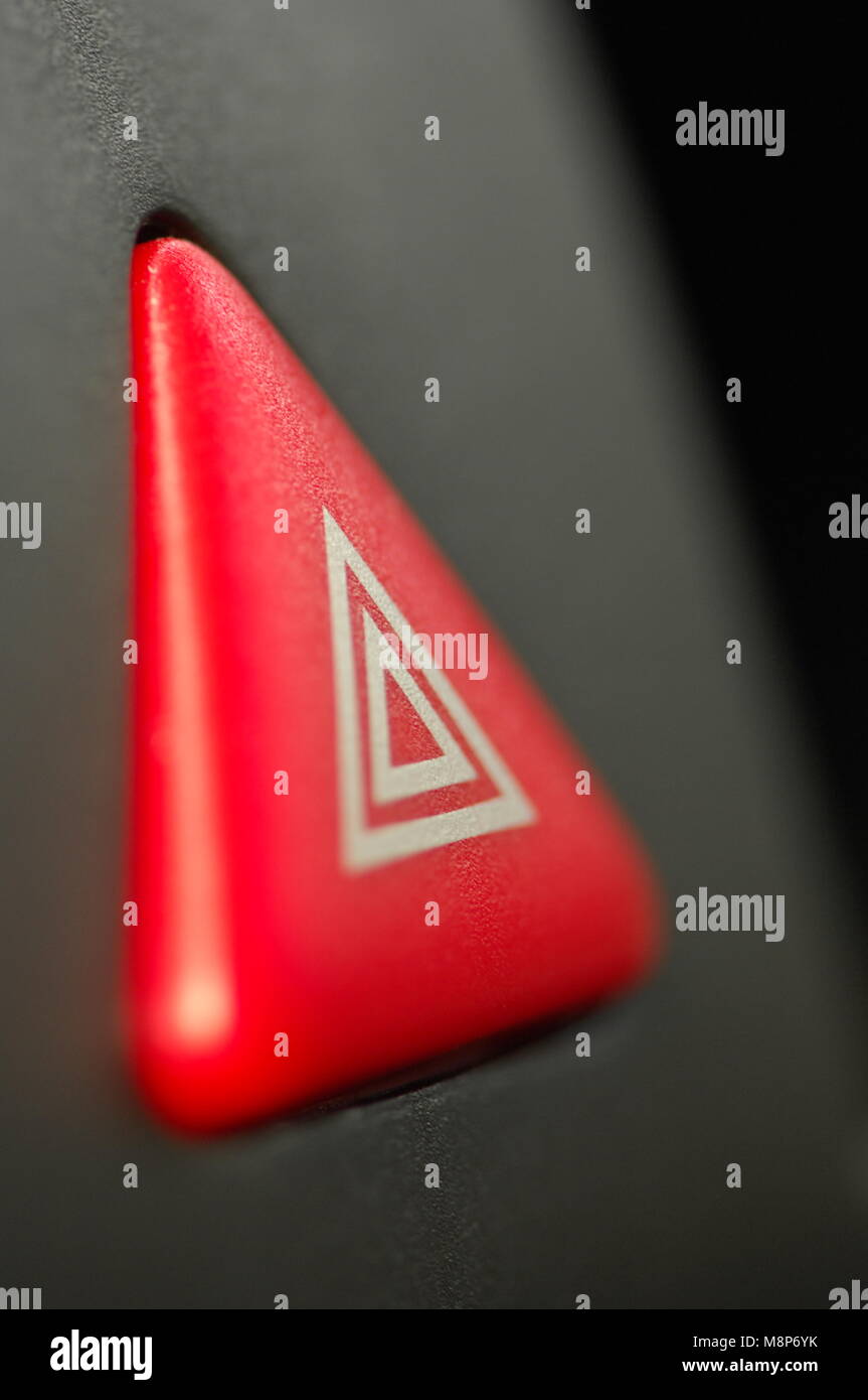 Red hazard warning triangular button on dashboard of vehicle Stock ...