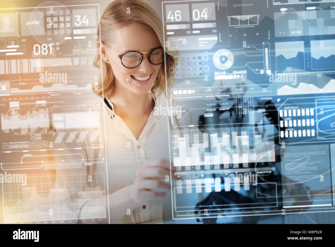 Smiling engineer feeling impressed while working with a little robot ...