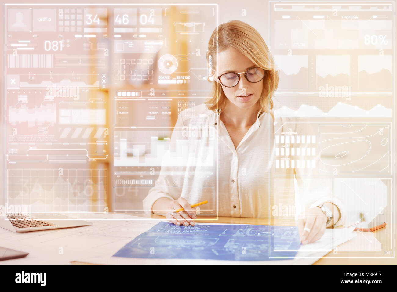 Concentrated engineer looking at the blueprint and thinking Stock Photo ...