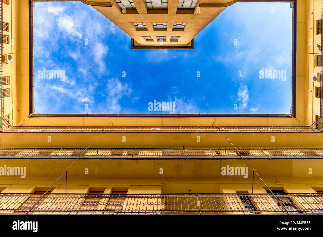 Yellow building and blue sky with clouds Stock Photo - Alamy