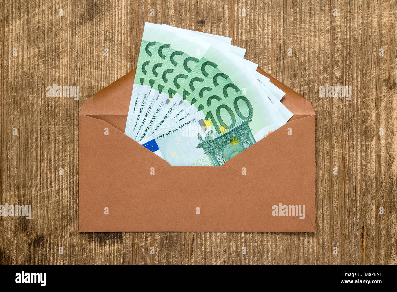 Brown envelope with Euro currency over wooden background Stock Photo ...