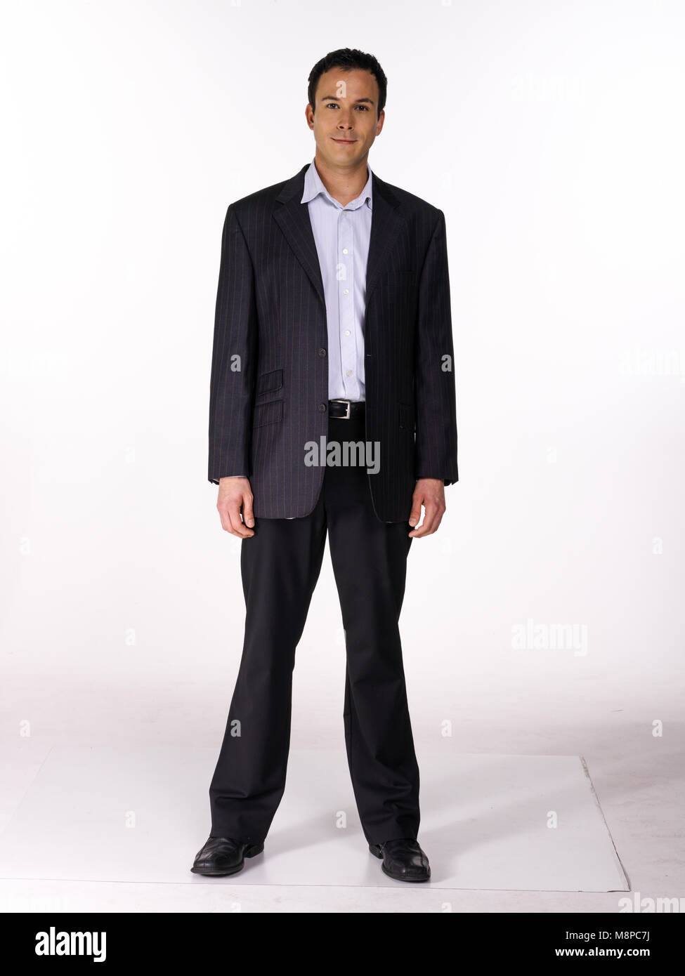 Studio portrait of young white male/man with dark hair against light ...