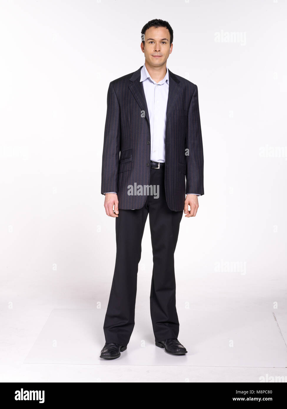 Studio portrait of young white male/man with dark hair against light ...