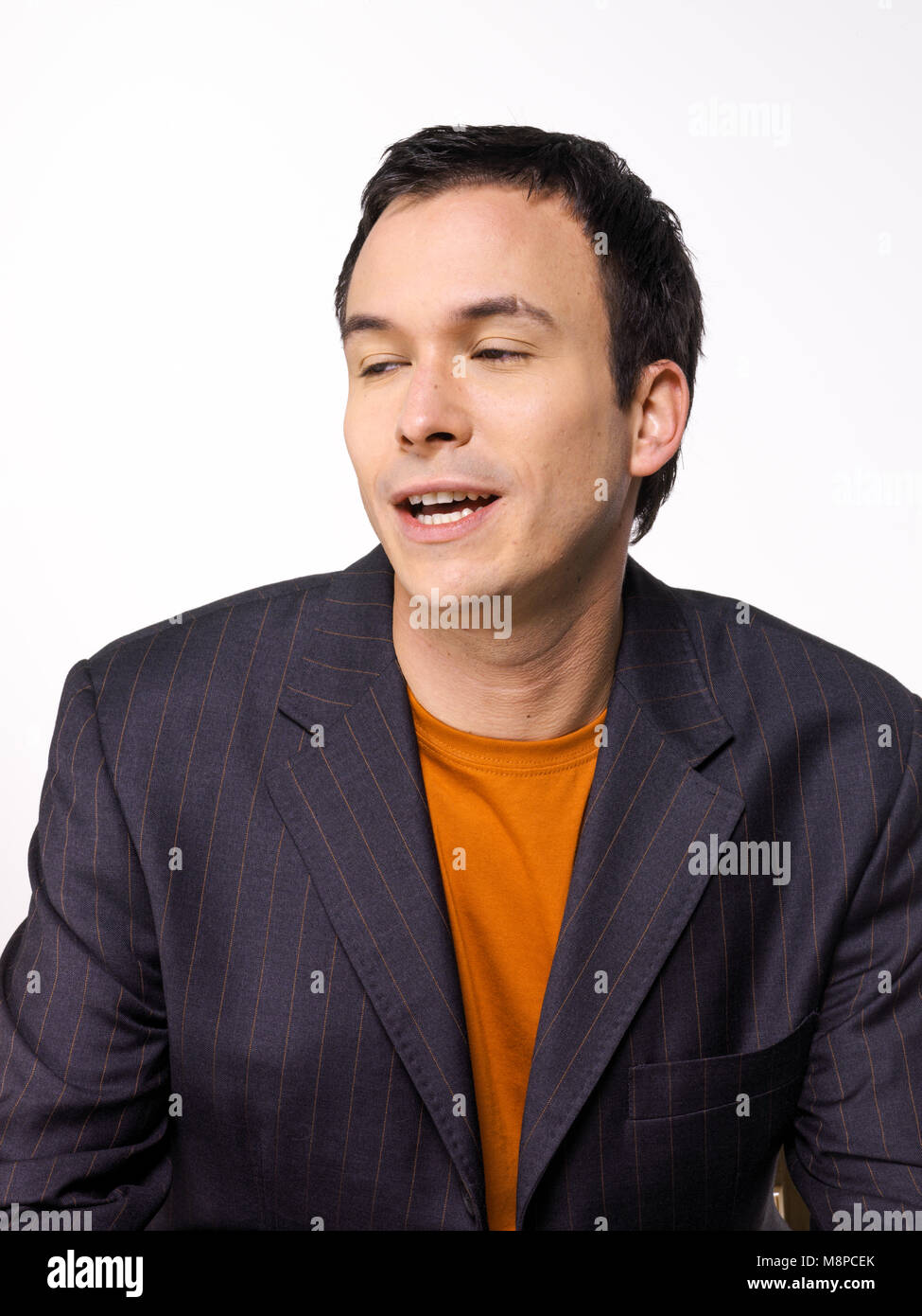 Studio portrait of young white male/man with dark hair against light ...