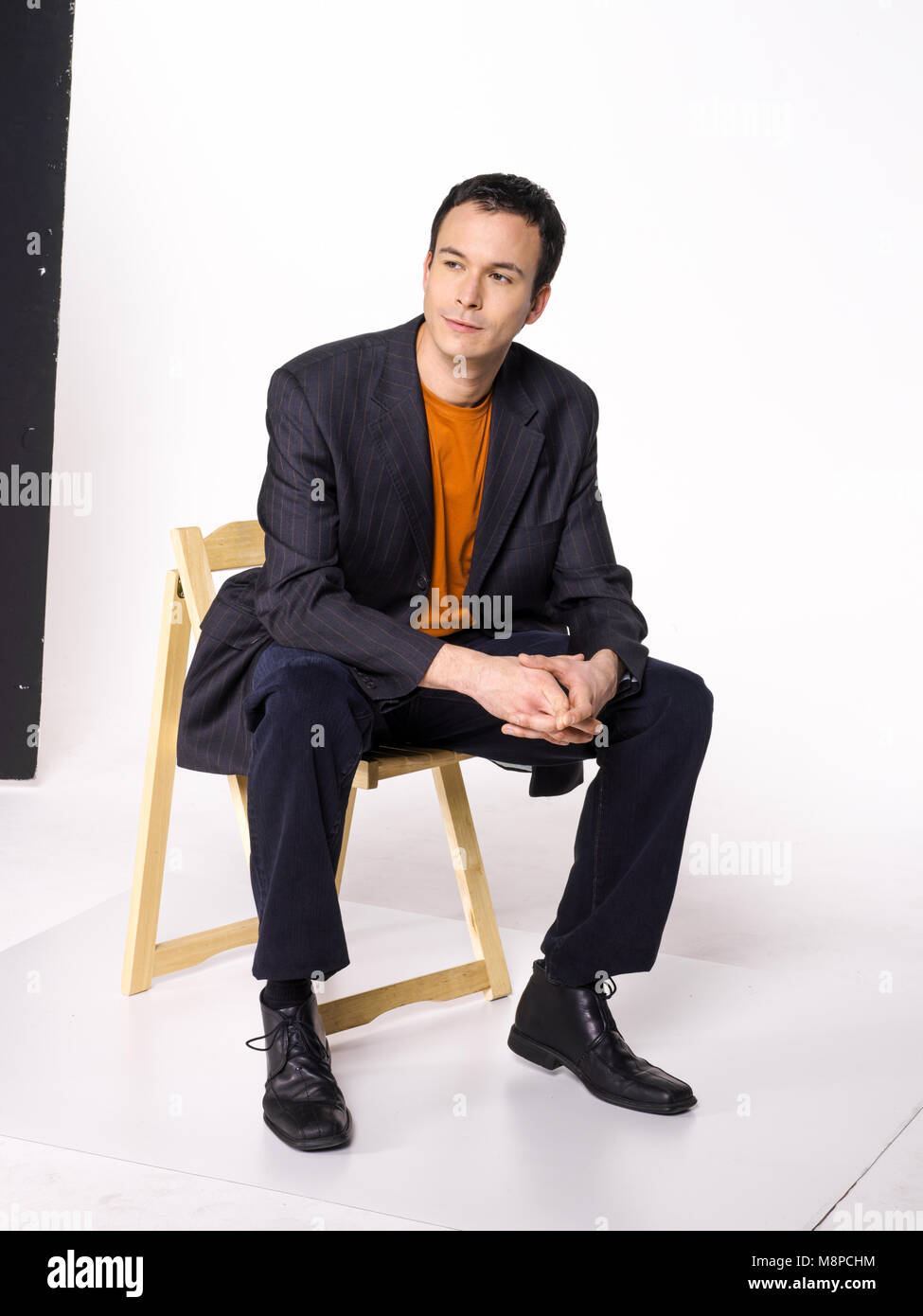 Studio portrait of young white male/man with dark hair against light ...