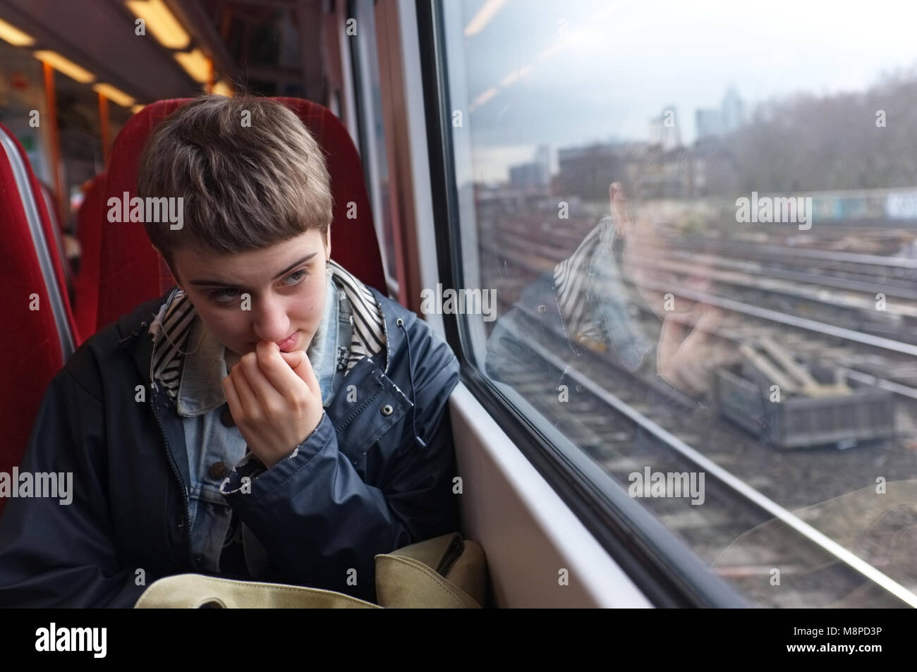 A nervous girl on a train Stock Photo - Alamy