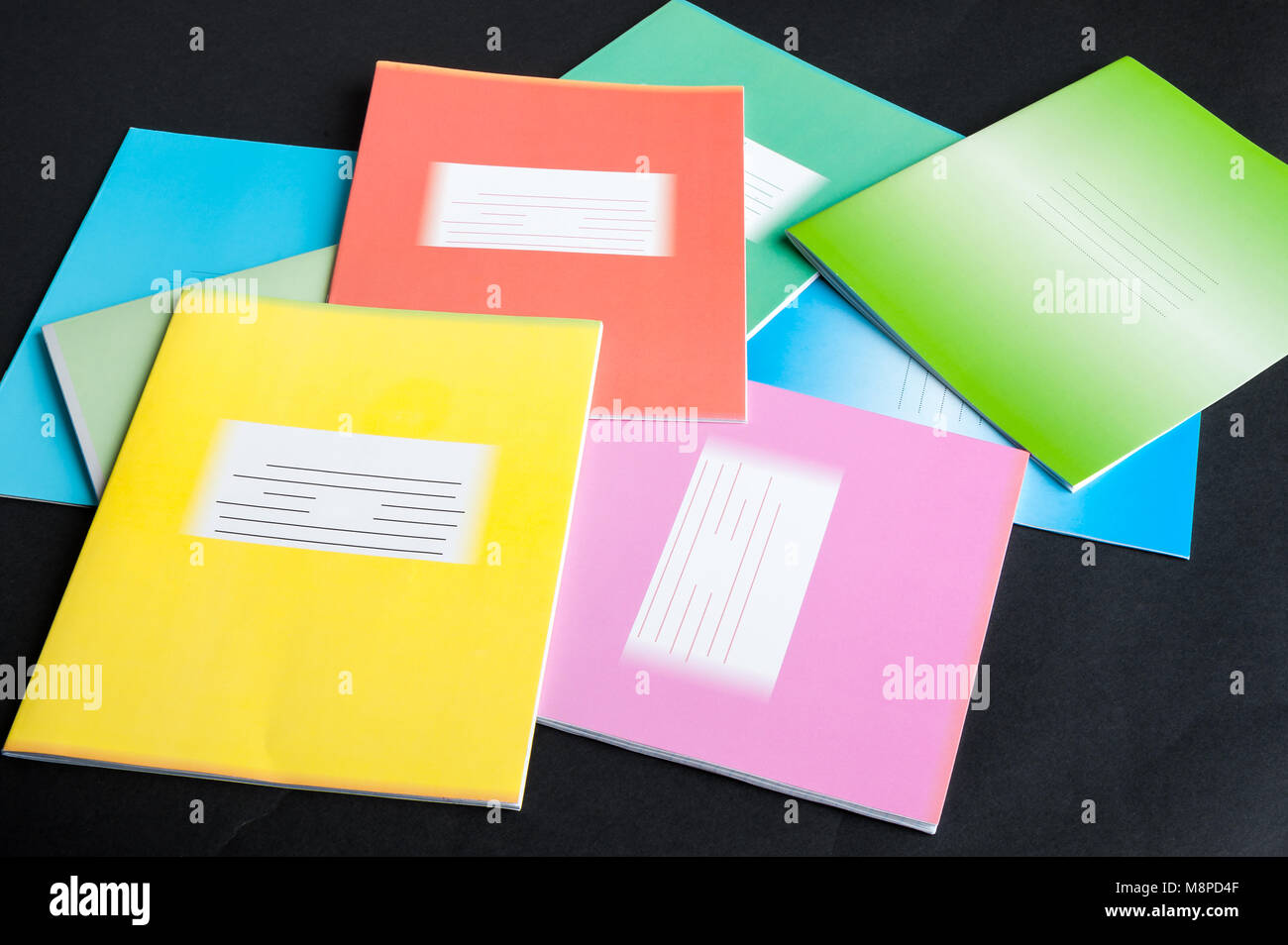 colorful school notebooks on black background Stock Photo - Alamy