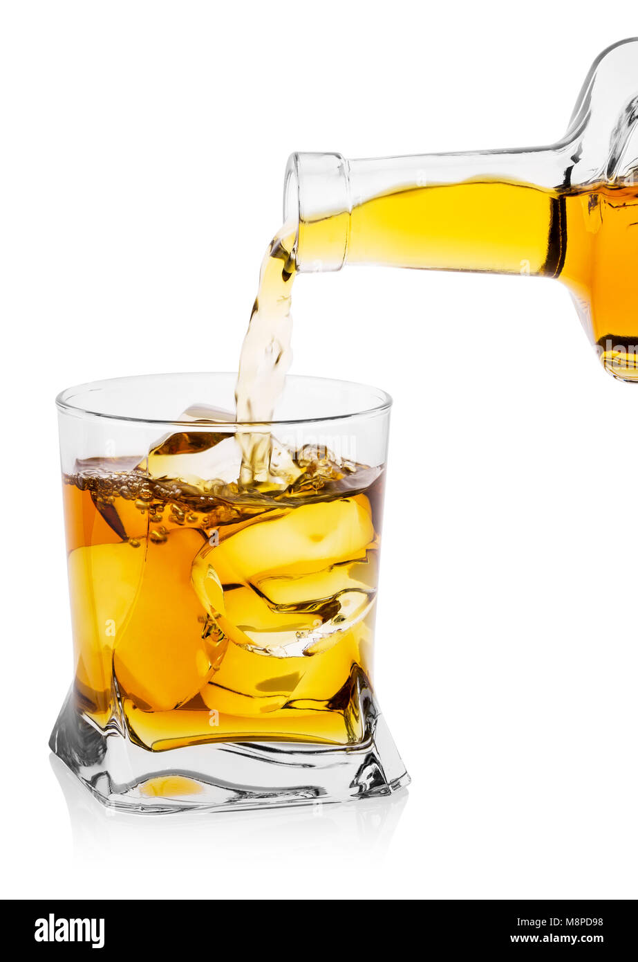 Whiskey pouring from bottle into transparent glass with ice Stock Photo ...
