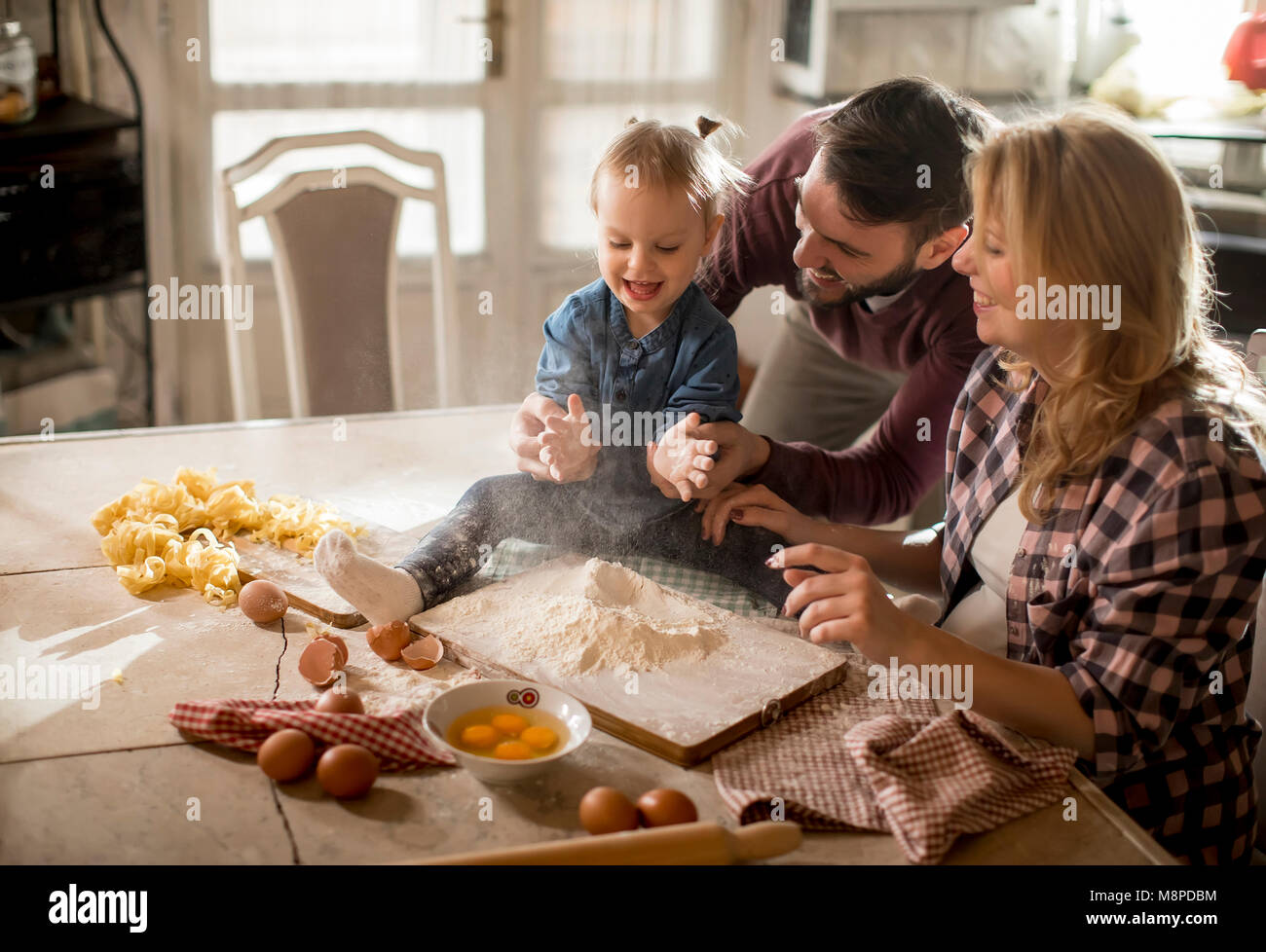 Happy family making pasta in the kitchen at home Stock Photo - Alamy