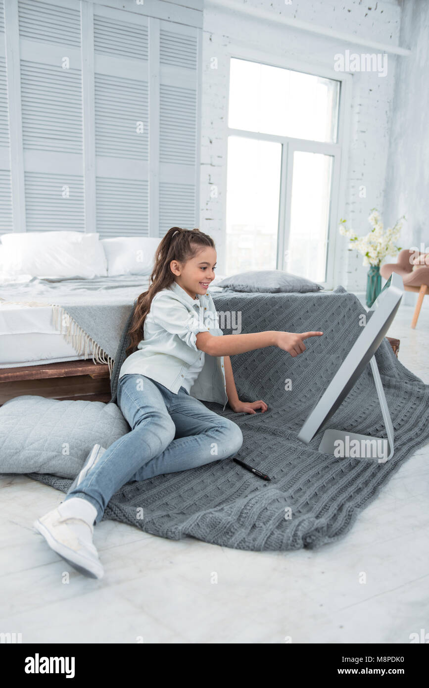 Happy cheerful girl pointing at the screen Stock Photo - Alamy