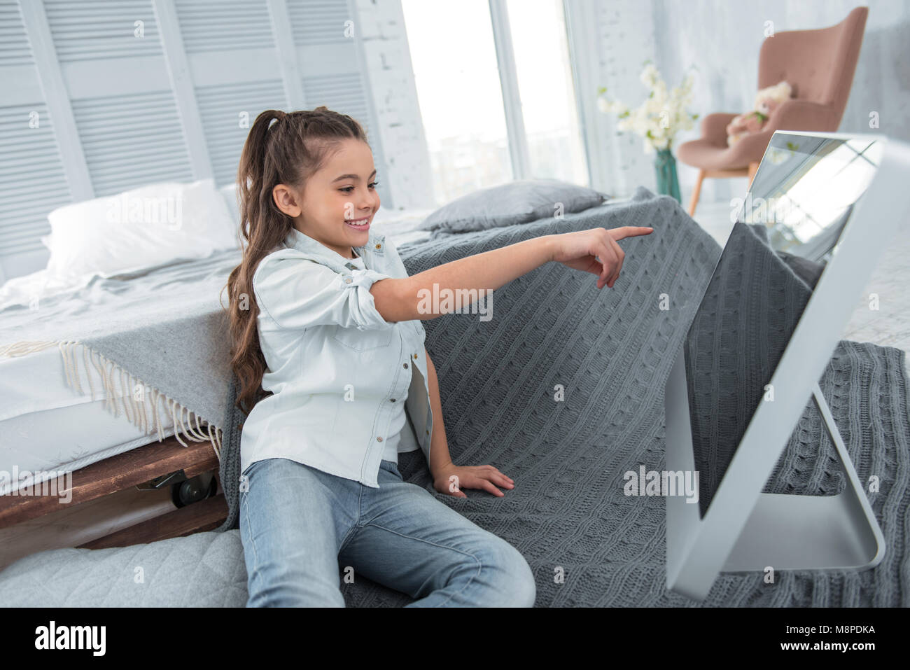 Positive cute girl pointing with her finger Stock Photo - Alamy