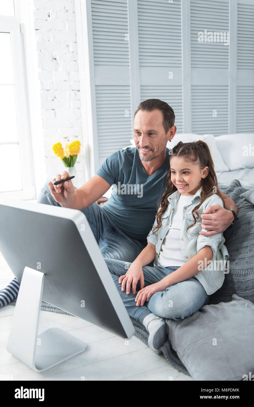 Nice pleasant man hugging his daughter Stock Photo - Alamy