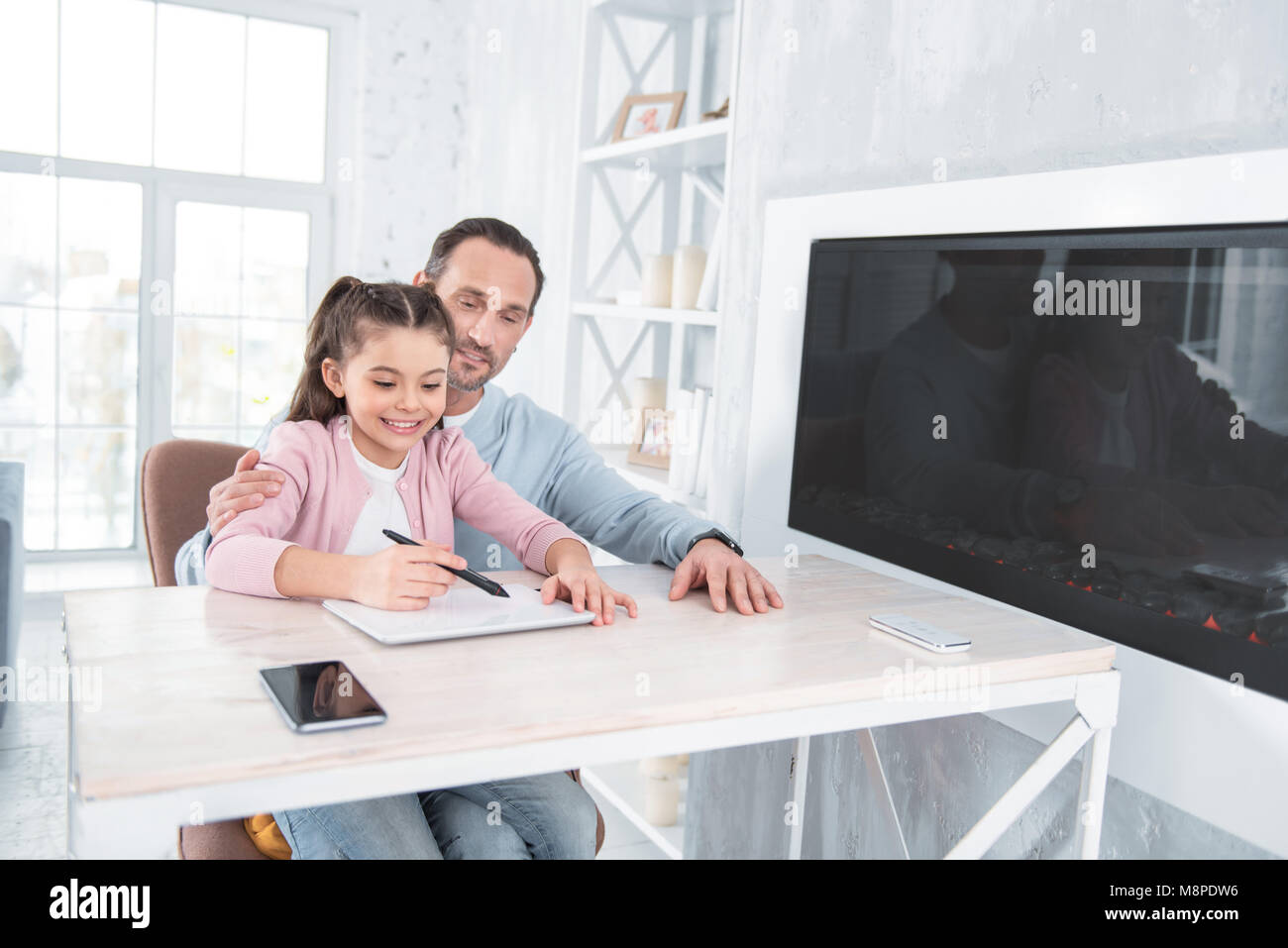 Nice positive girl doing her home task Stock Photo - Alamy