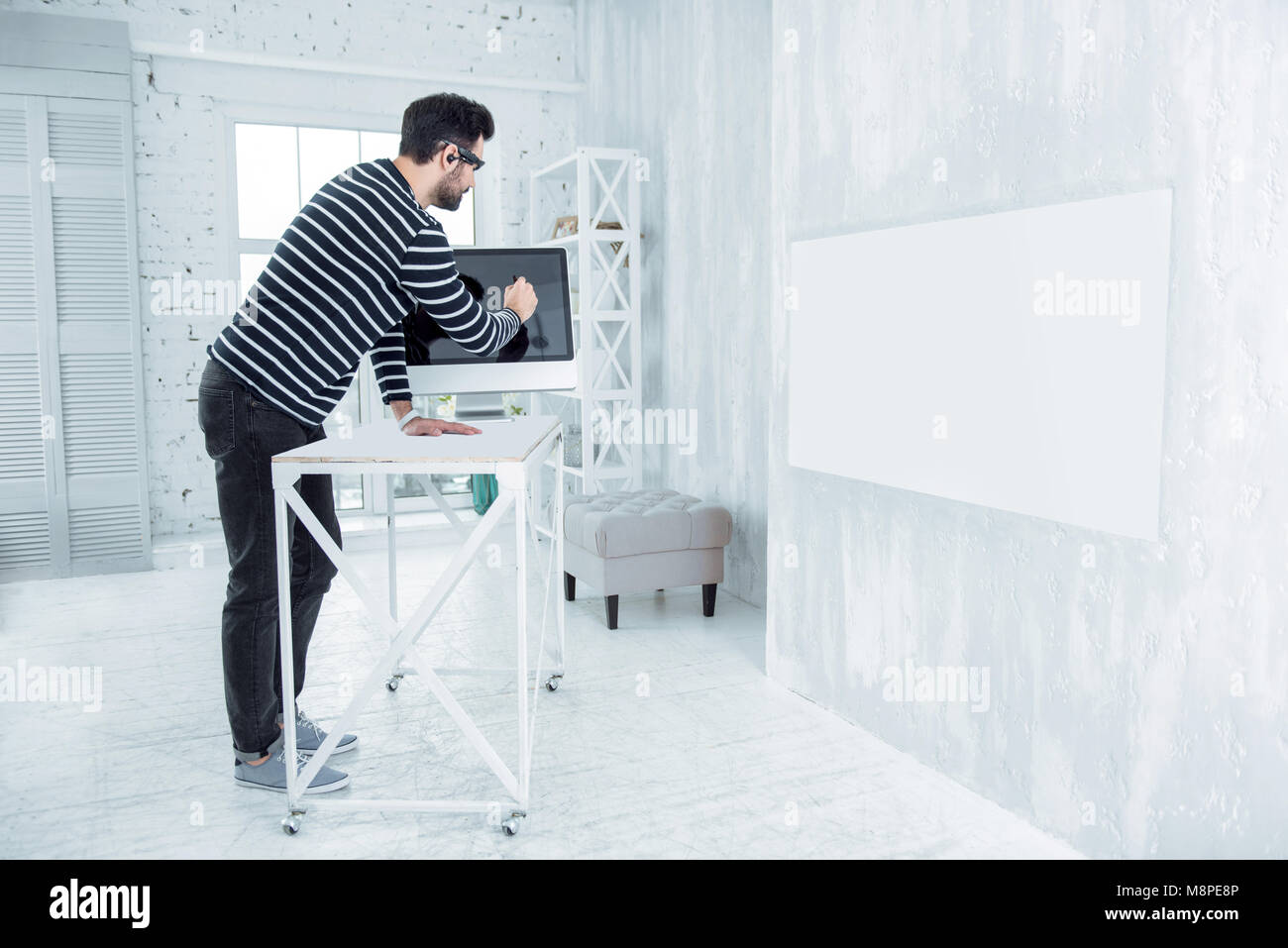 Busy young man touching computer Stock Photo - Alamy