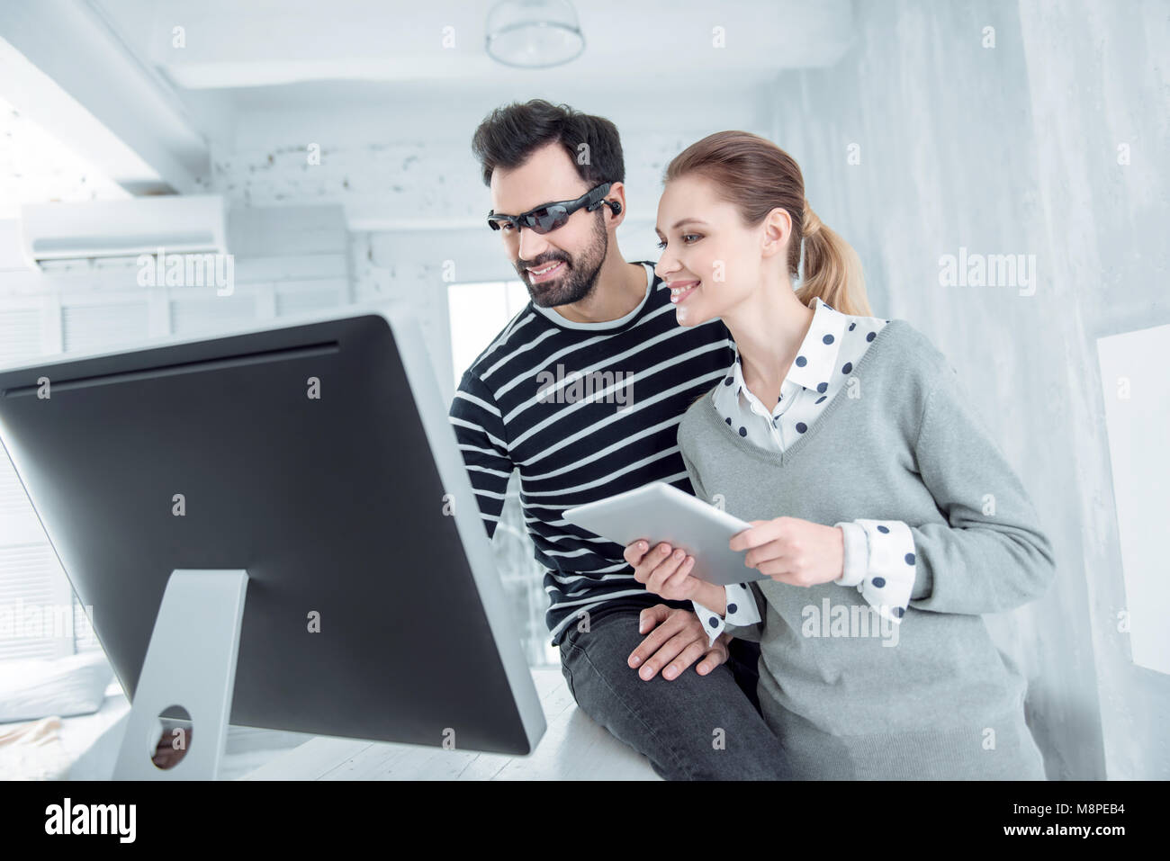 Delighted colleagues looking at screen of computer Stock Photo - Alamy