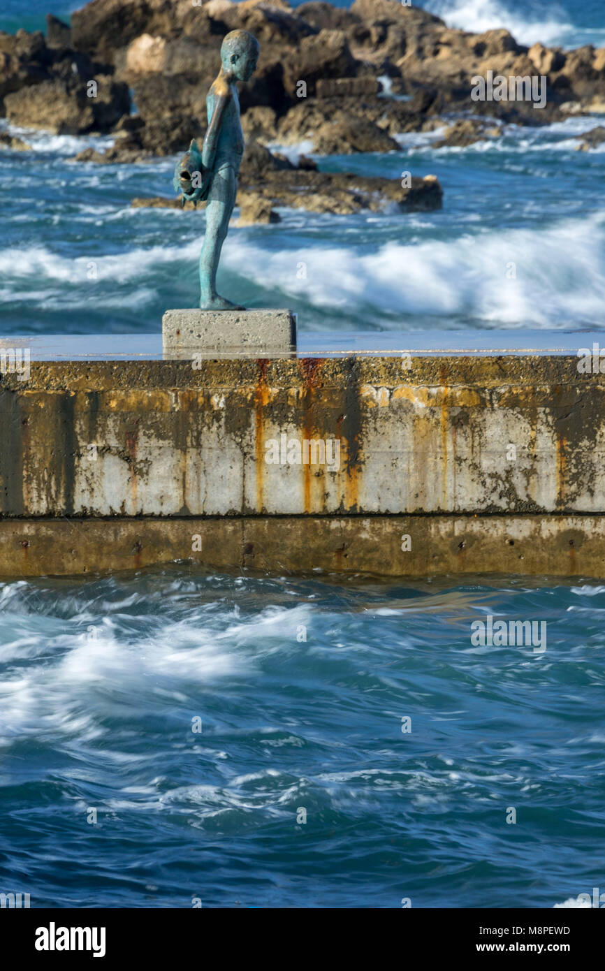 Boy with fish statue on Mediterranean coast of Paphos harbour, Cyprus ...