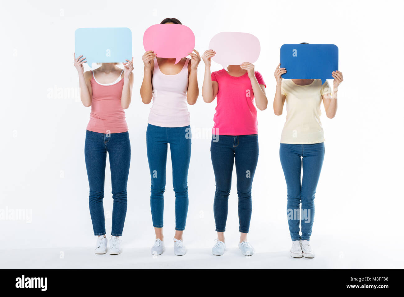 Nice positive women hiding their faces Stock Photo - Alamy