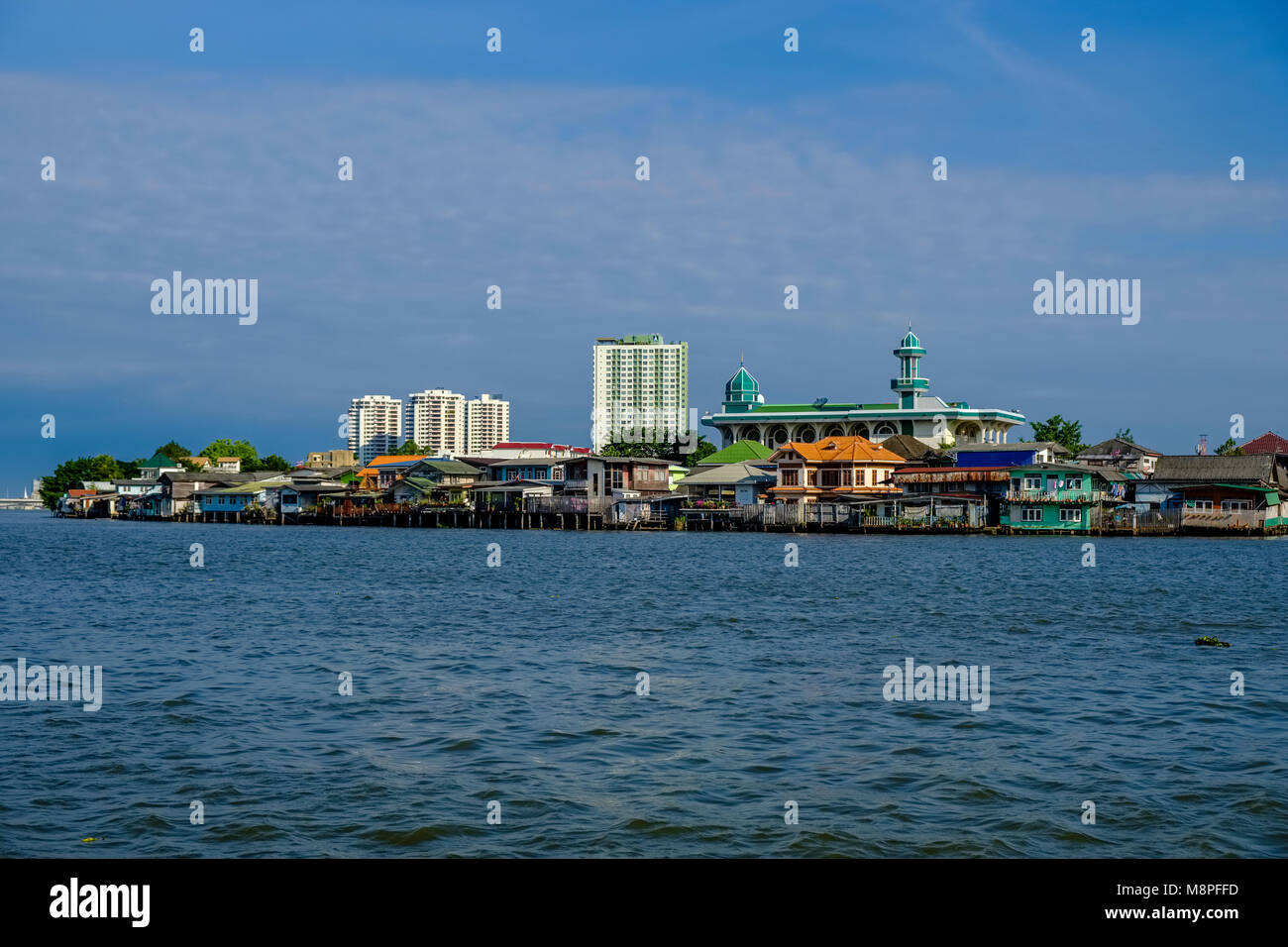 Local houses on stilts, a mosque and some high rise buildings, seen ...