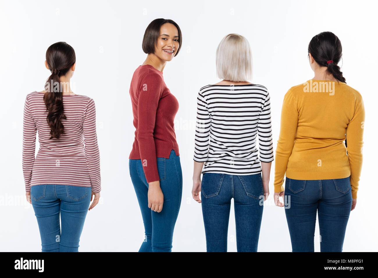 Happy young woman standing among her friends Stock Photo - Alamy