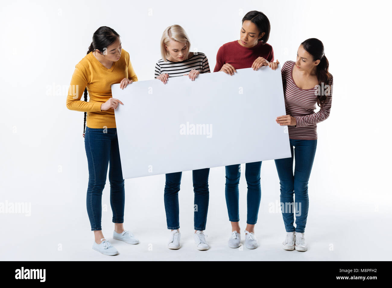 Smart confident women looking at the poster Stock Photo - Alamy