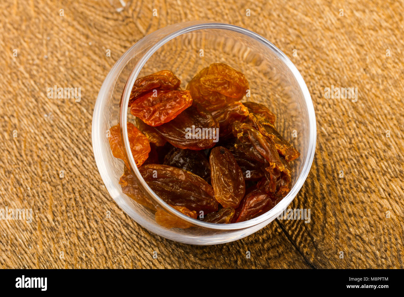Dry Raisin in the bowl over the wooden background Stock Photo - Alamy