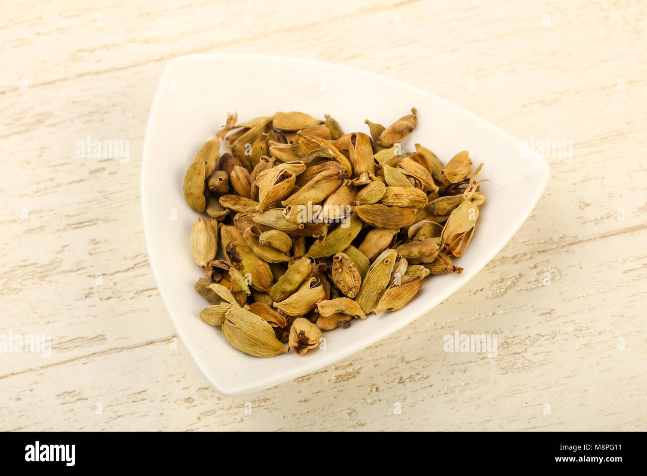 Dry cardamom seeds heap in the bowl Stock Photo - Alamy