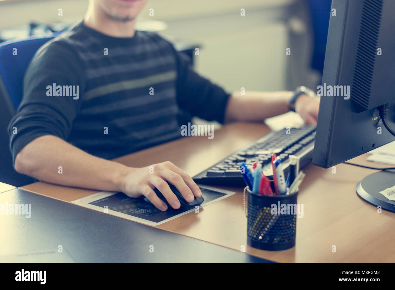 Person sitting at office workspace and working on computer Stock Photo ...