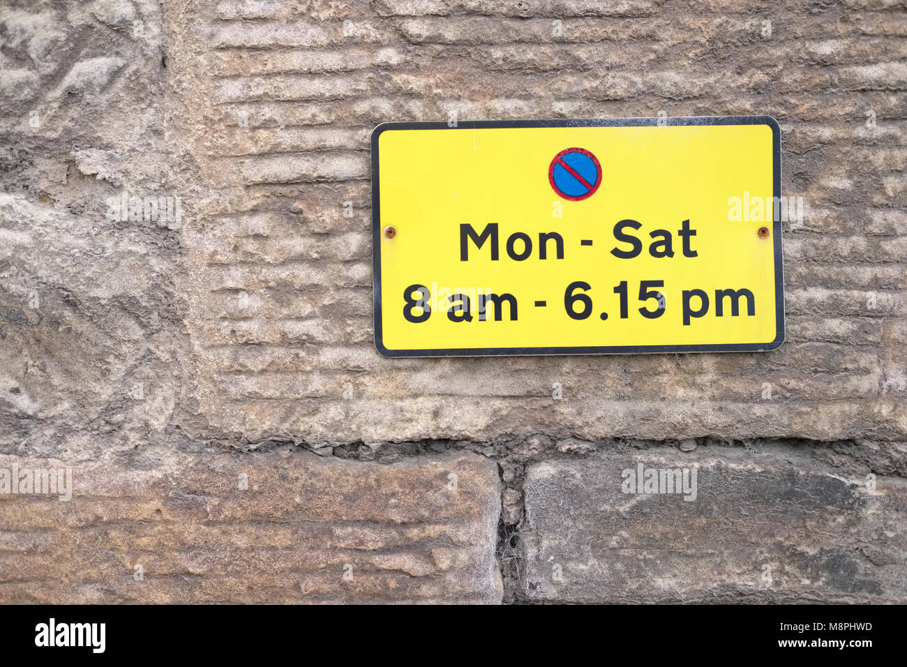 No parking Monday to Friday during day sign post on stone wall simple ...