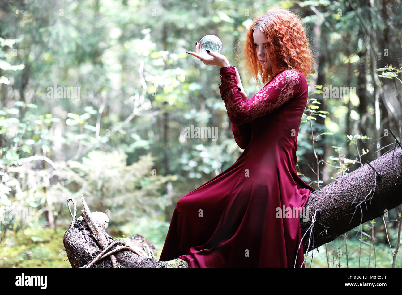 The red-haired witch holds a ritual with a crystal ball Stock Photo - Alamy