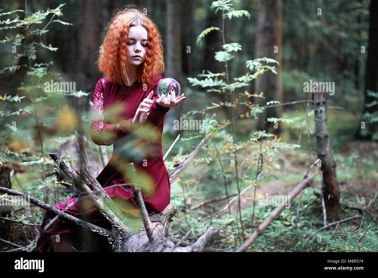 The red-haired witch holds a ritual with a crystal ball Stock Photo - Alamy