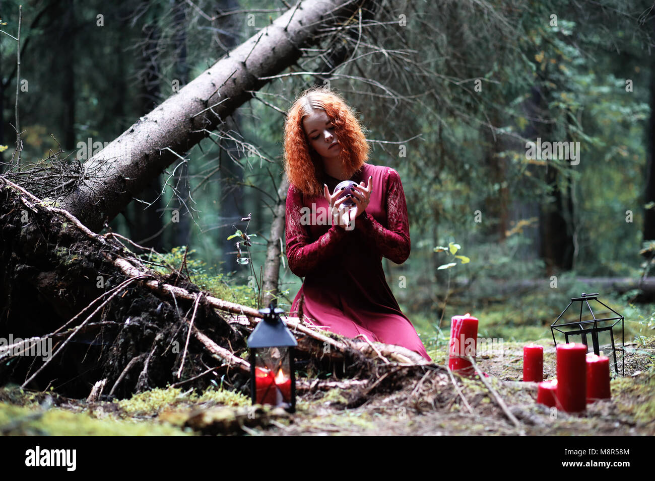 The red-haired witch holds a ritual with a crystal ball Stock Photo - Alamy
