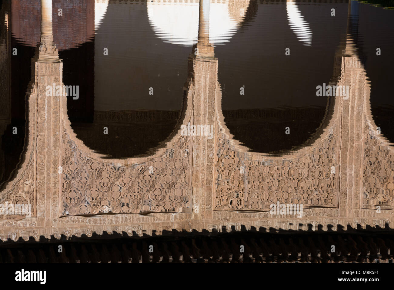 Arabesque arches reflection in the mirror of water. Alhambra of Granada ...
