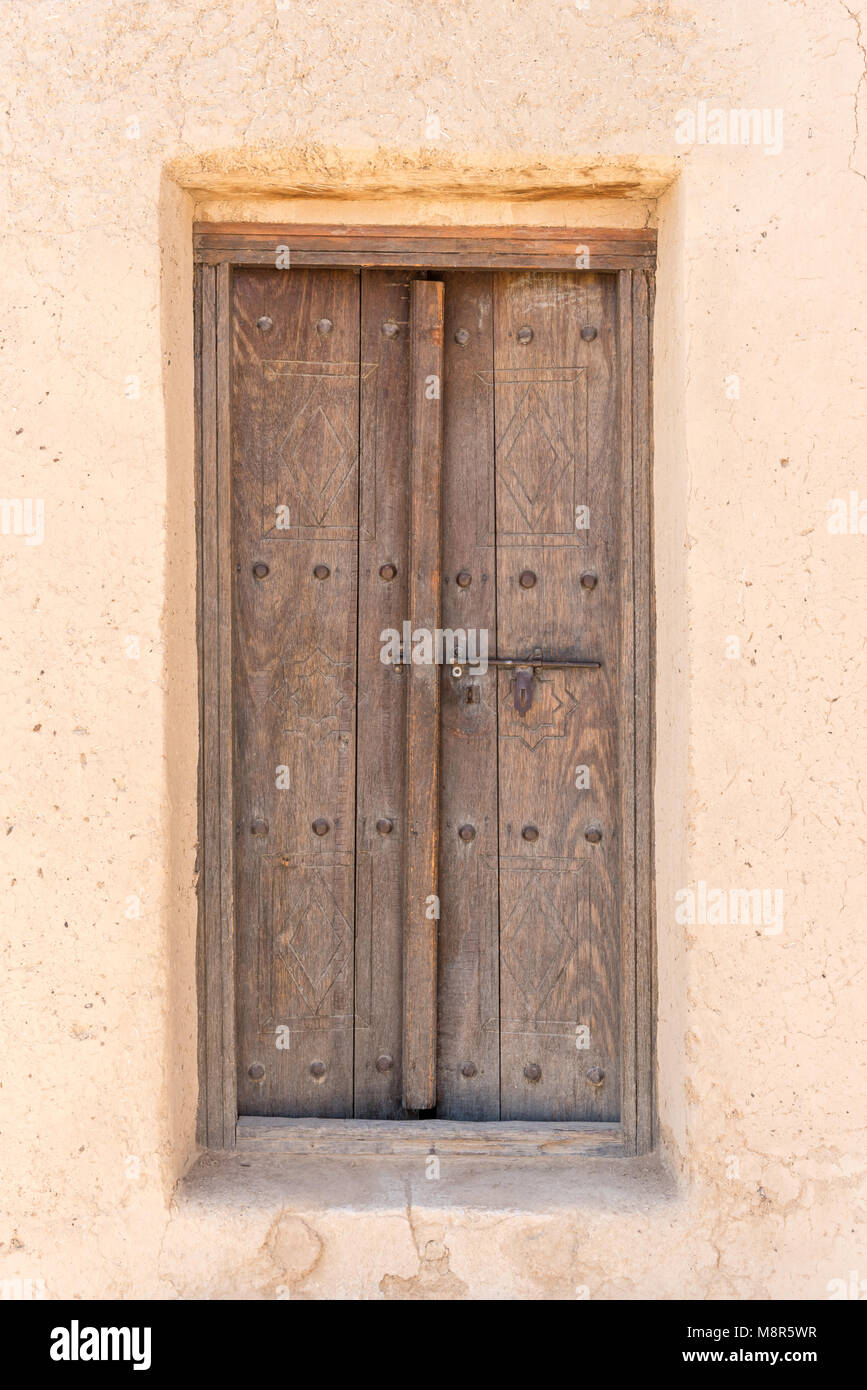 Old arabic wooden door set into mud-walled building of Al Jahili fort ...