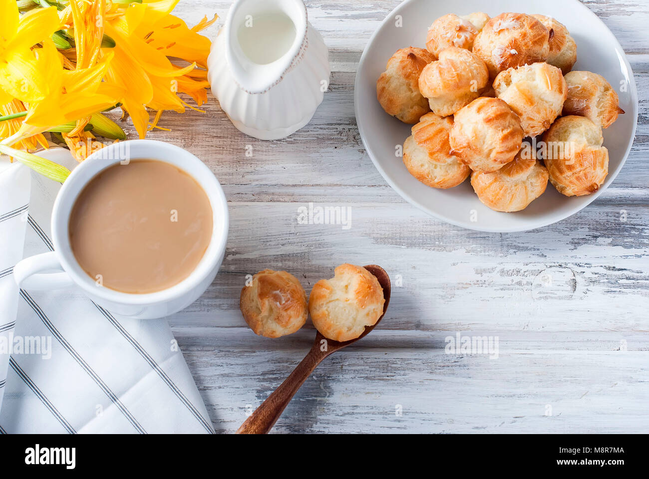 Breakfast, a cup of coffee and eclairs, flowers on a white background ...