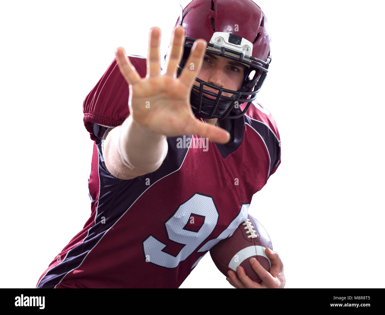 Portrait of American football player pointing against gray background ...