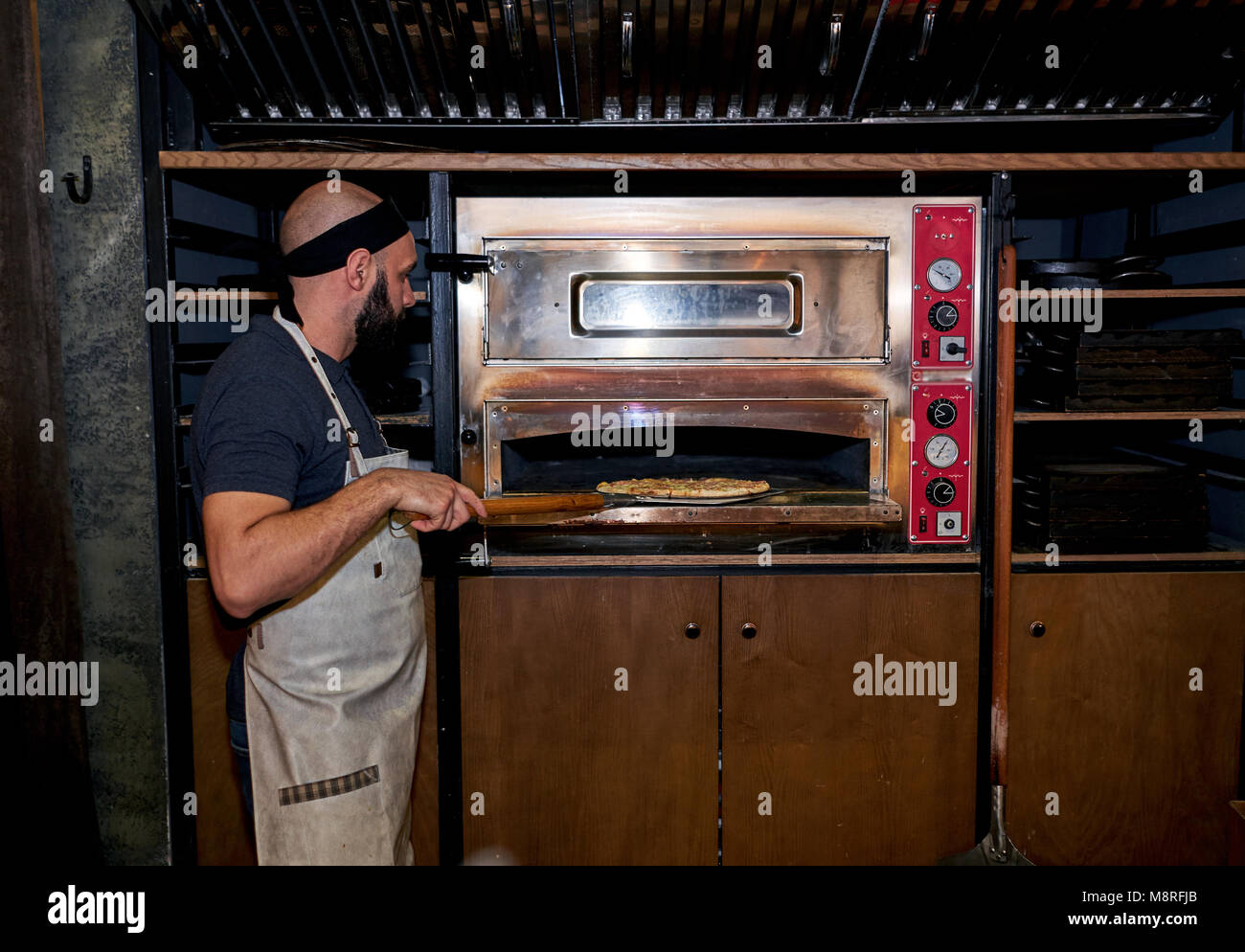 man pulls the pizza out of the oven Stock Photo - Alamy