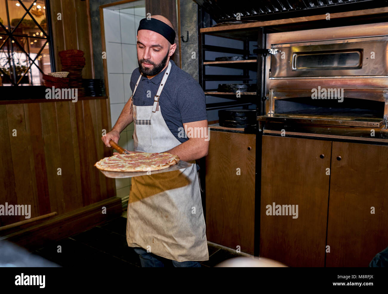 man pulls the pizza out of the oven Stock Photo - Alamy