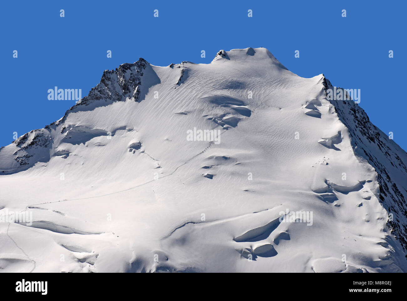 Large number of mountaineers at the summit region of Dom mountain ...