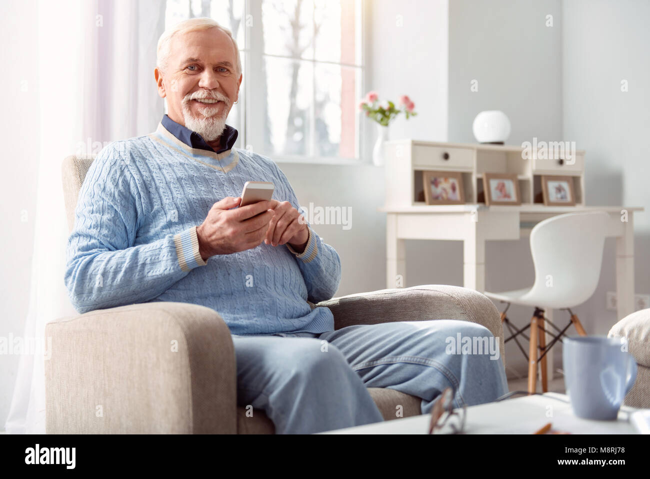Cheerful senior man scrolling social media timeline on his phone Stock ...