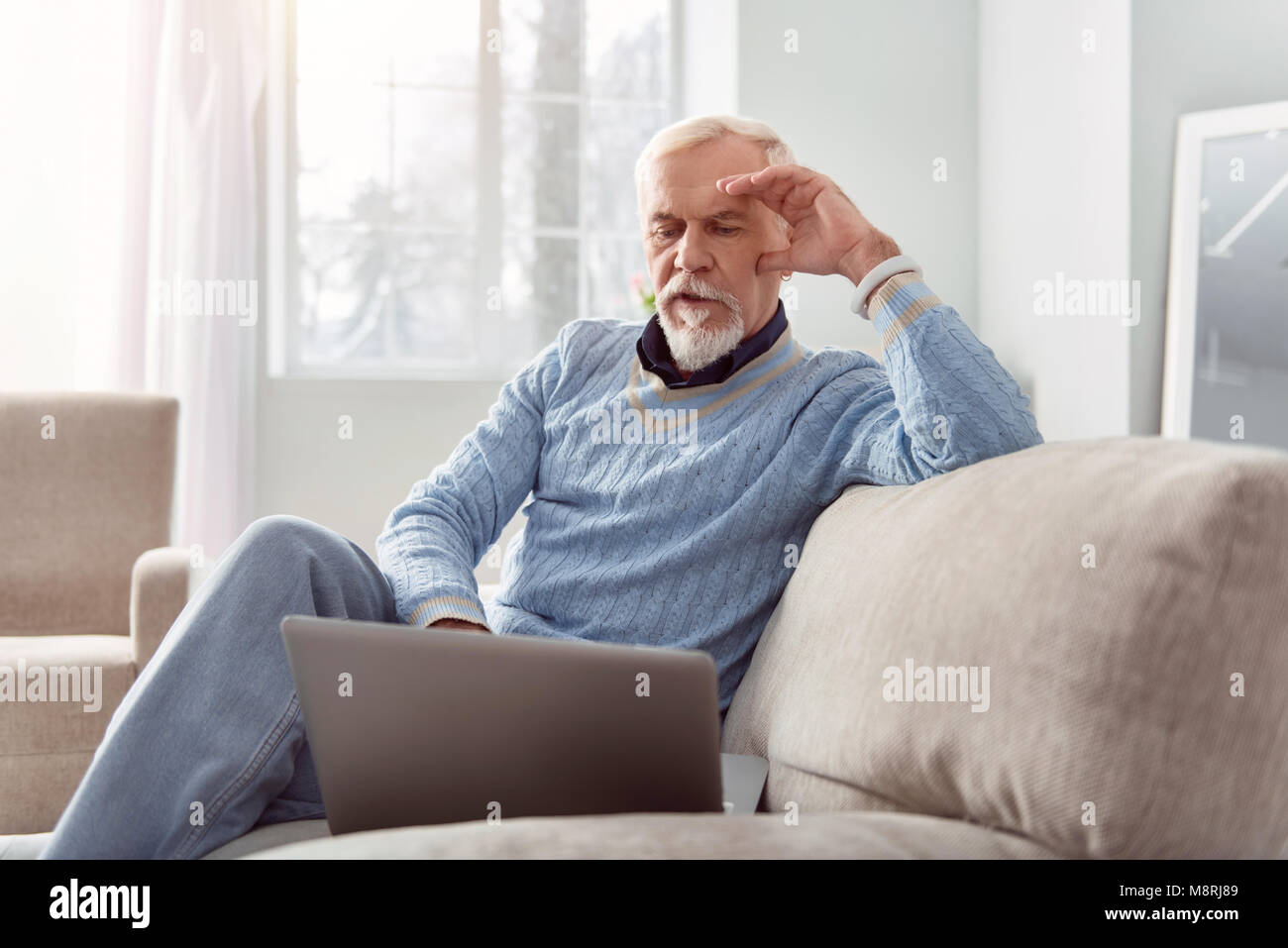 Handsome elderly man surfing Internet on laptop Stock Photo - Alamy