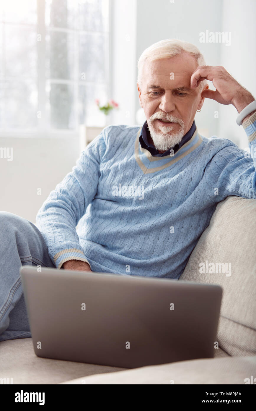 Pleasant senior man watching video on laptop Stock Photo - Alamy