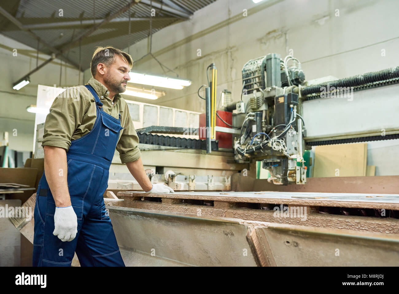Factory Worker using Cutting Machine Stock Photo - Alamy