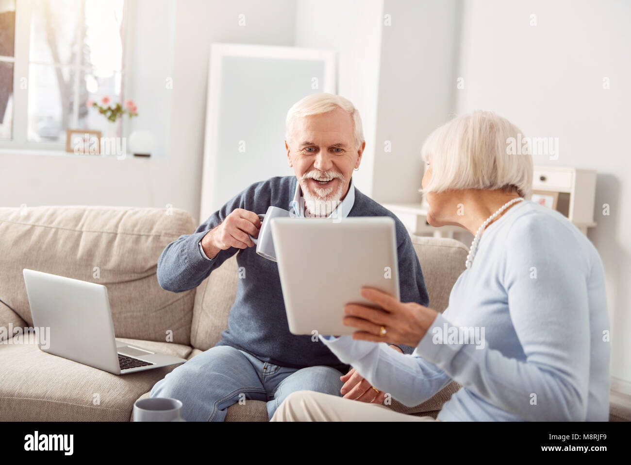 Cheerful senior woman showing her husband news update Stock Photo - Alamy
