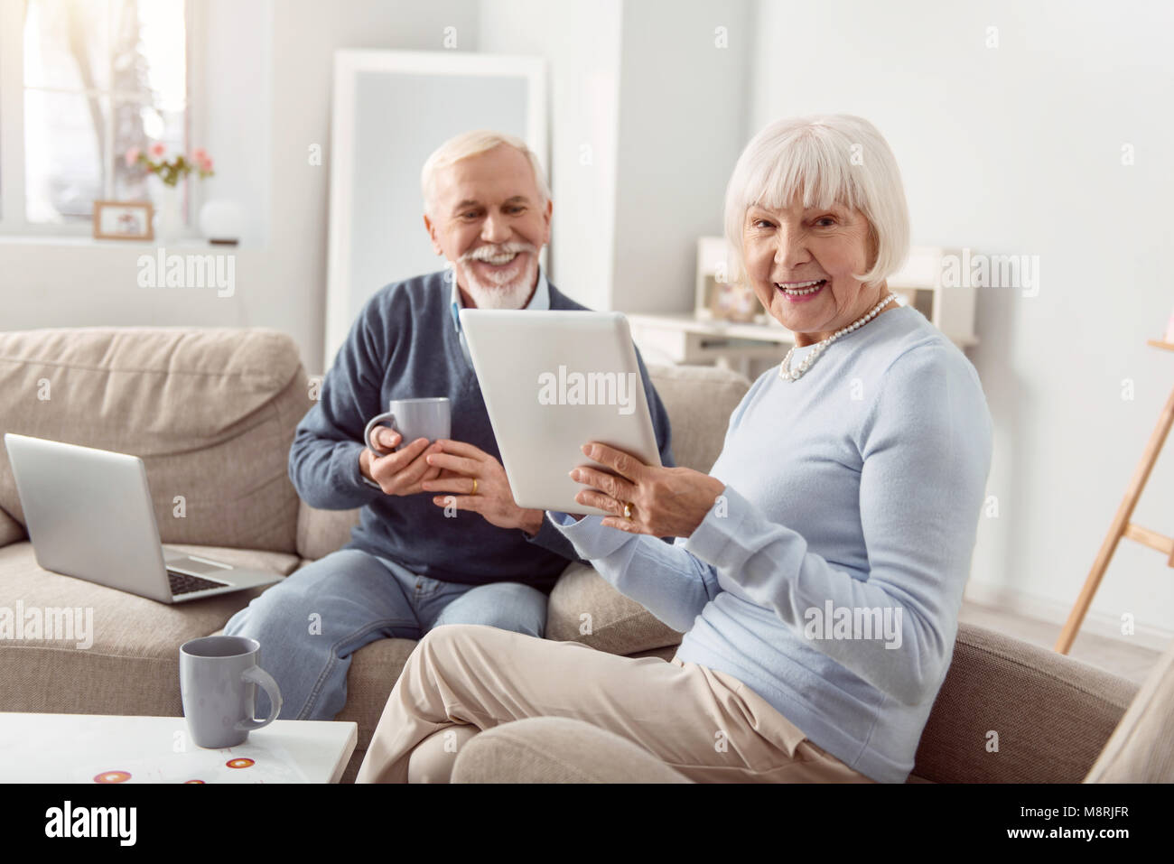 Upbeat senior couple reading social media posts and laughing Stock ...